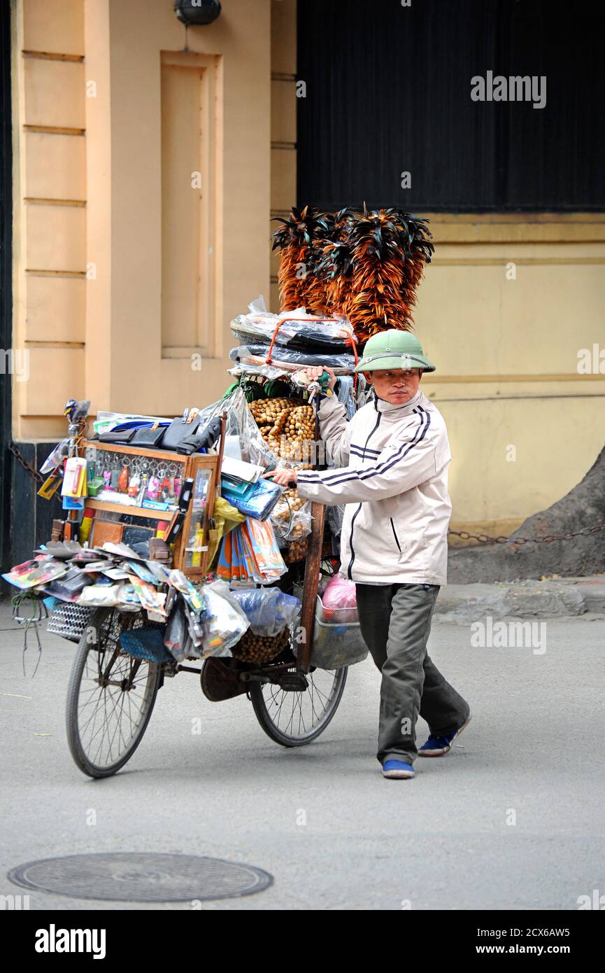 Itinerant Vietnamese street vendor with bicycle laden with wares. Hanoi ...