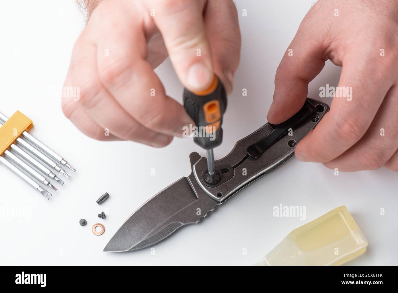 Technician joints the parts of a folding knife together with a ...