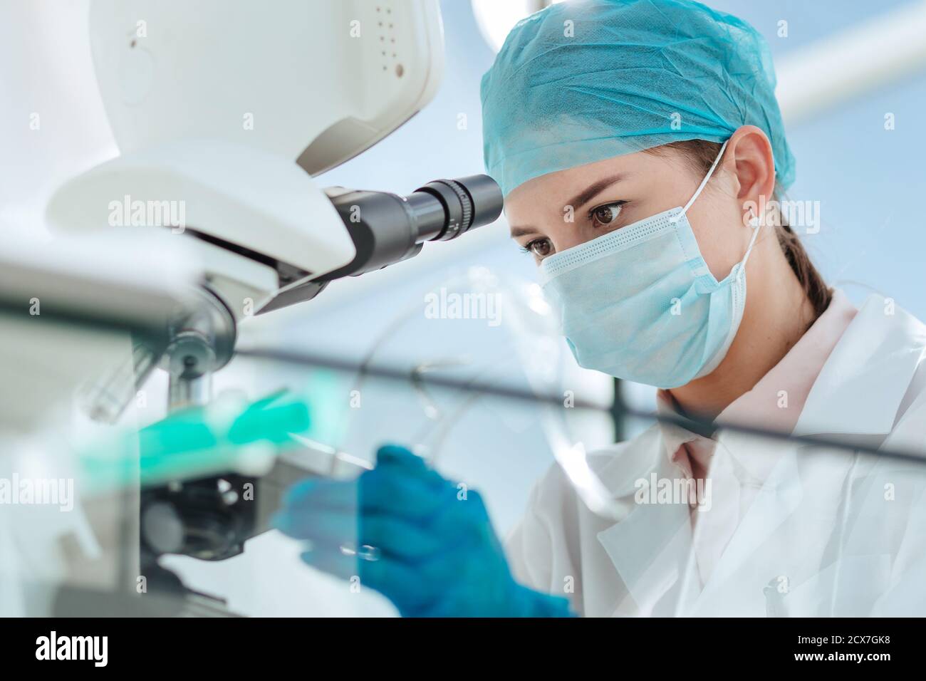 close up. female researcher looking through a microscope Stock Photo ...
