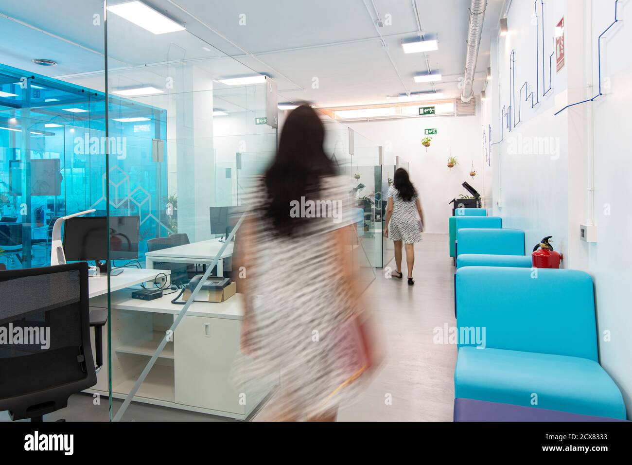 Moving shadow of woman walking inside modern office Stock Photo - Alamy
