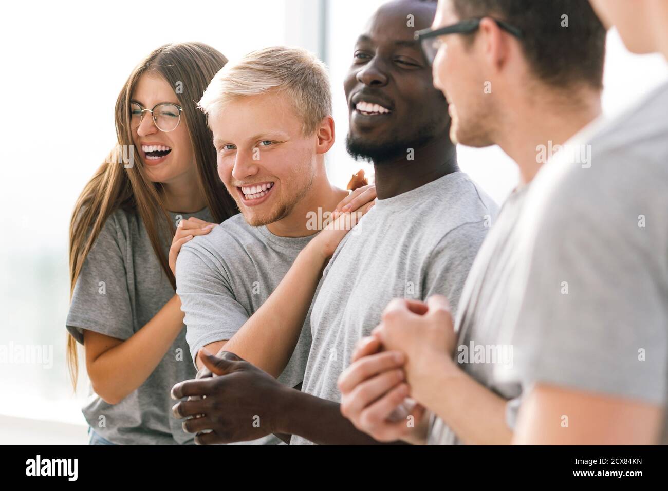 group of happy young people standing in a bright room Stock Photo - Alamy