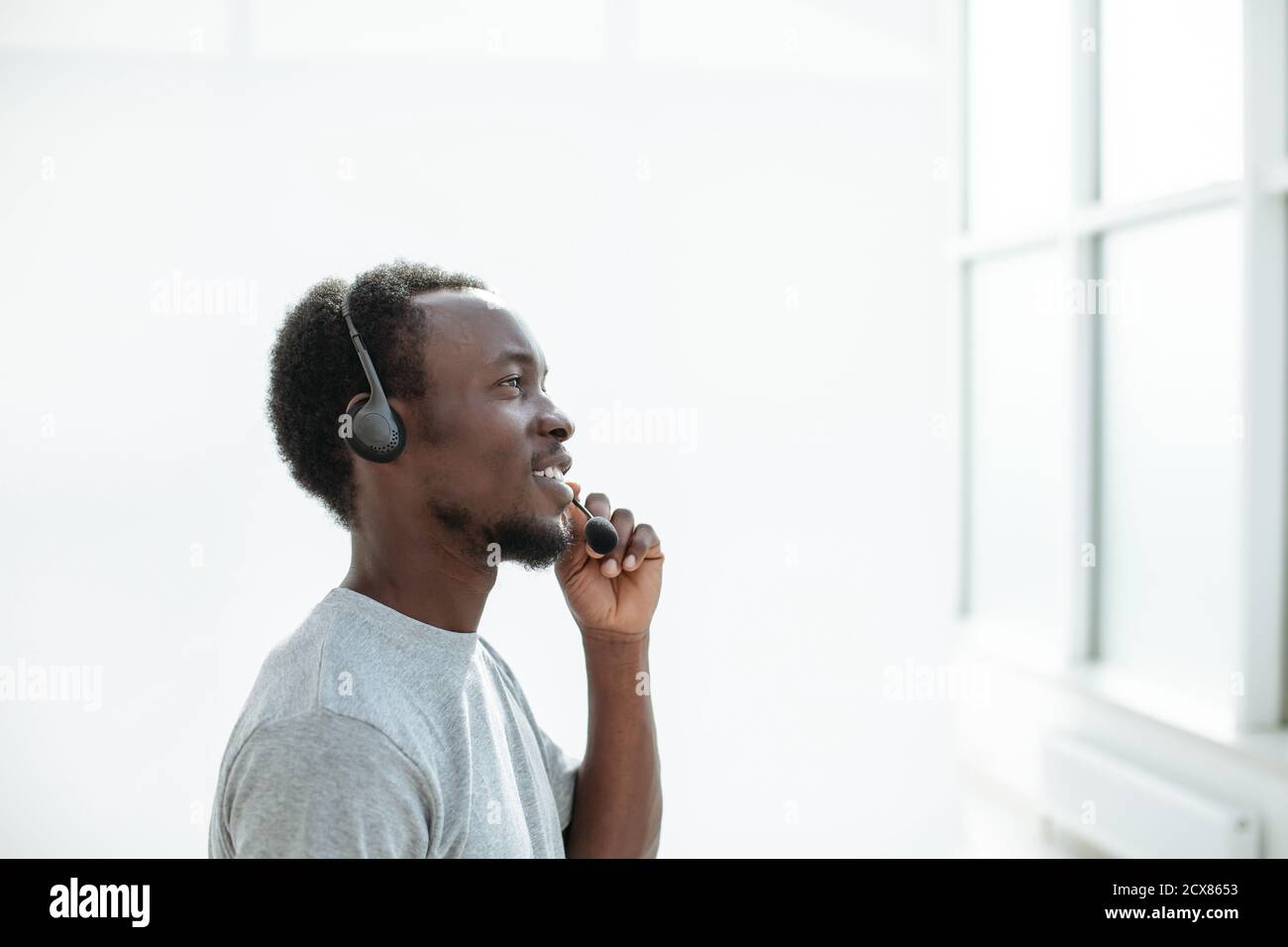 side view. young man with headset talking into microphone Stock Photo ...