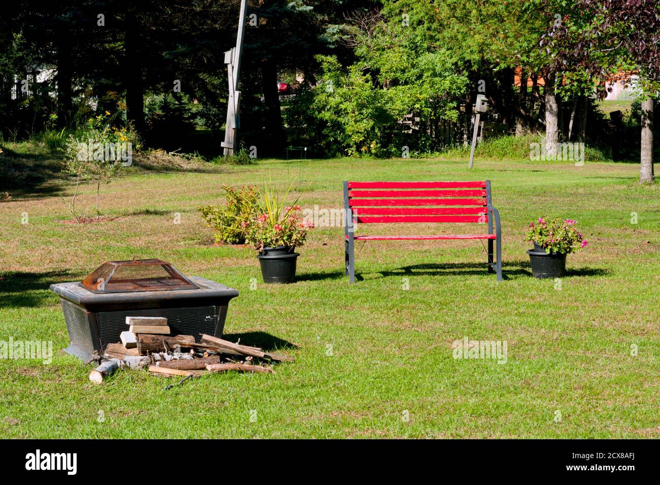 Self contained fire pit and red bench Stock Photo - Alamy