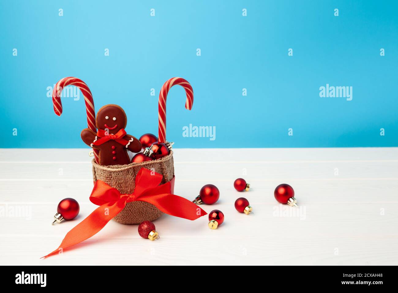 Gingerbread man and candy canes in a basket against blue Stock Photo ...