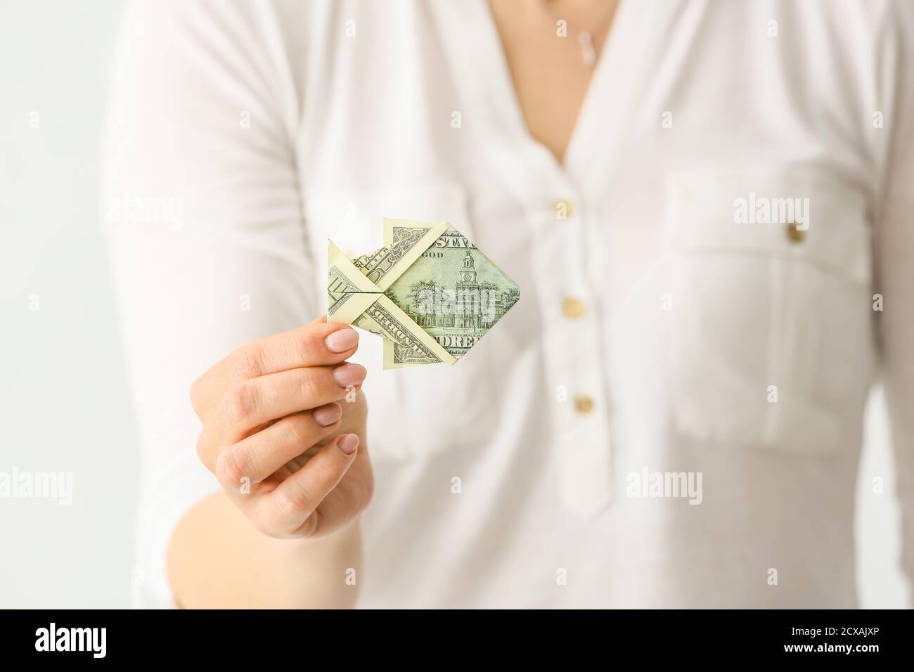 Woman with origami fish made of dollar banknote, closeup Stock Photo ...