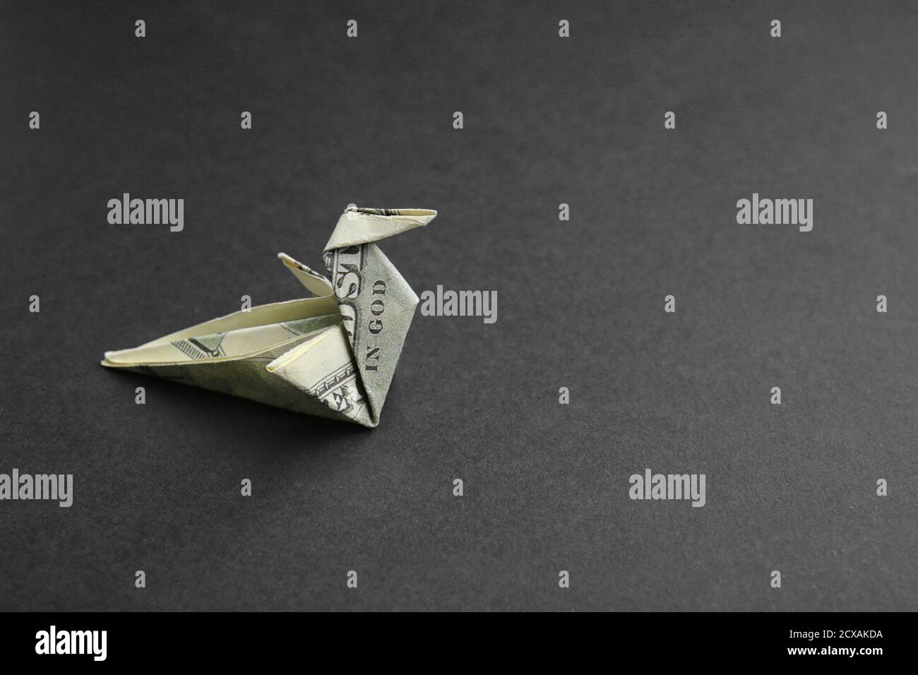 Origami bird made of dollar banknote on black background Stock Photo ...