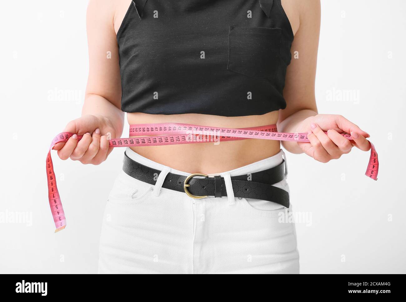 Skinny woman measuring her waist on light background. Concept of ...