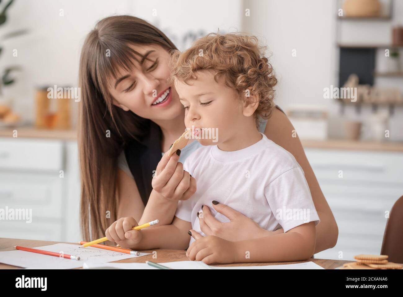 Working mother with little son in kitchen at home Stock Photo - Alamy