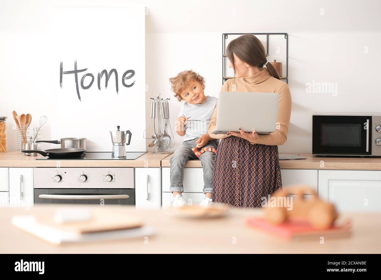 Working mother with little son in kitchen at home Stock Photo - Alamy