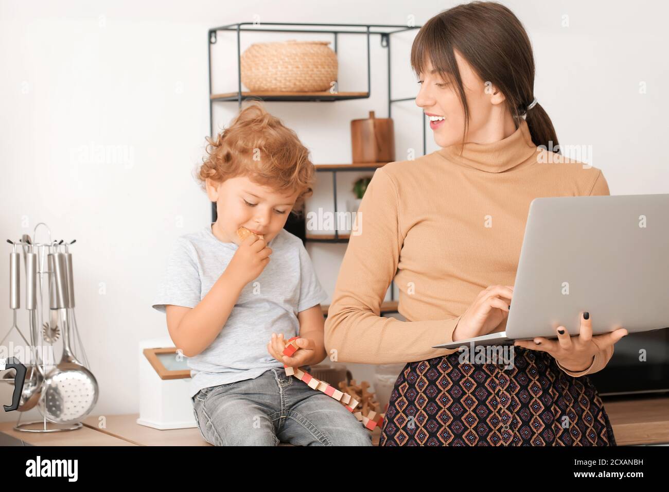 Working mother with little son in kitchen at home Stock Photo - Alamy