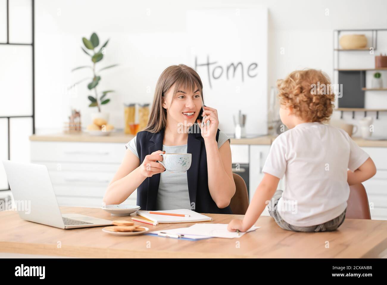 Working mother with little son in kitchen at home Stock Photo - Alamy