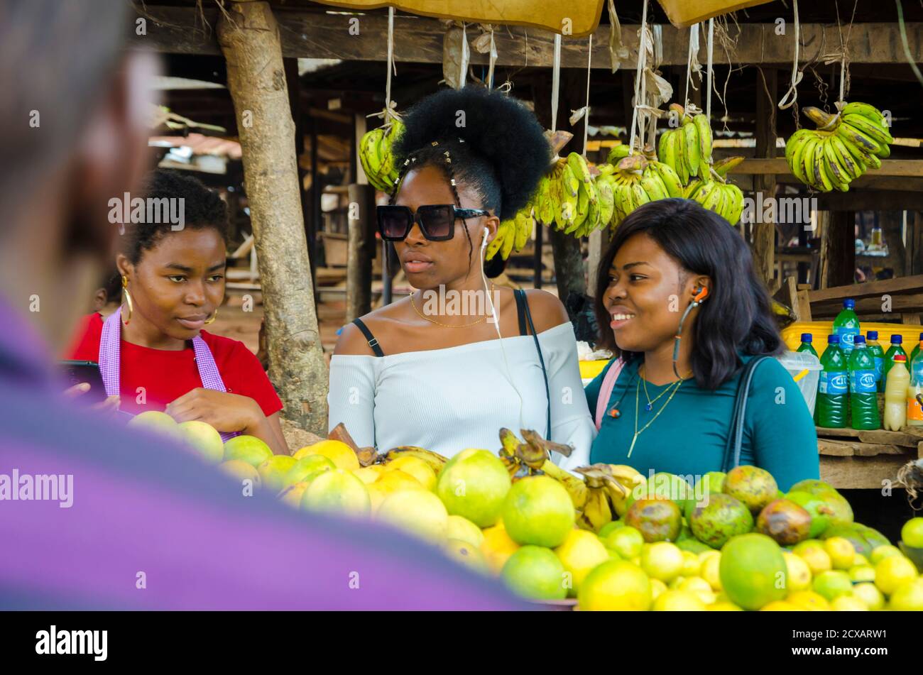a beautiful african market woman and her customers feeling excited as ...