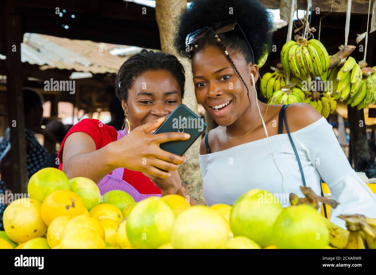 a beautiful african market woman and her customers feels happy about ...
