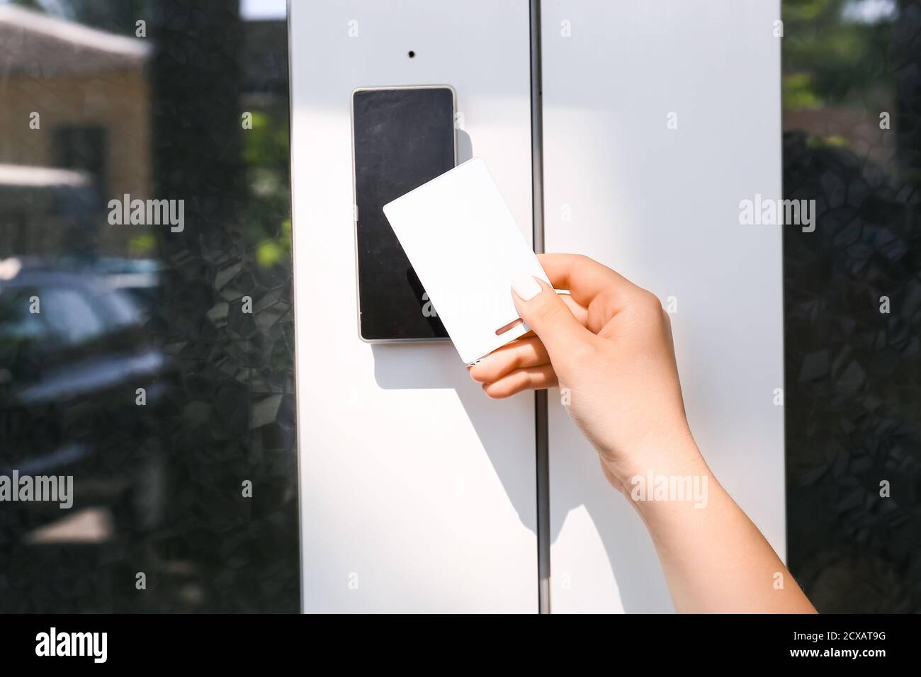 Woman using card to open door outdoors Stock Photo - Alamy