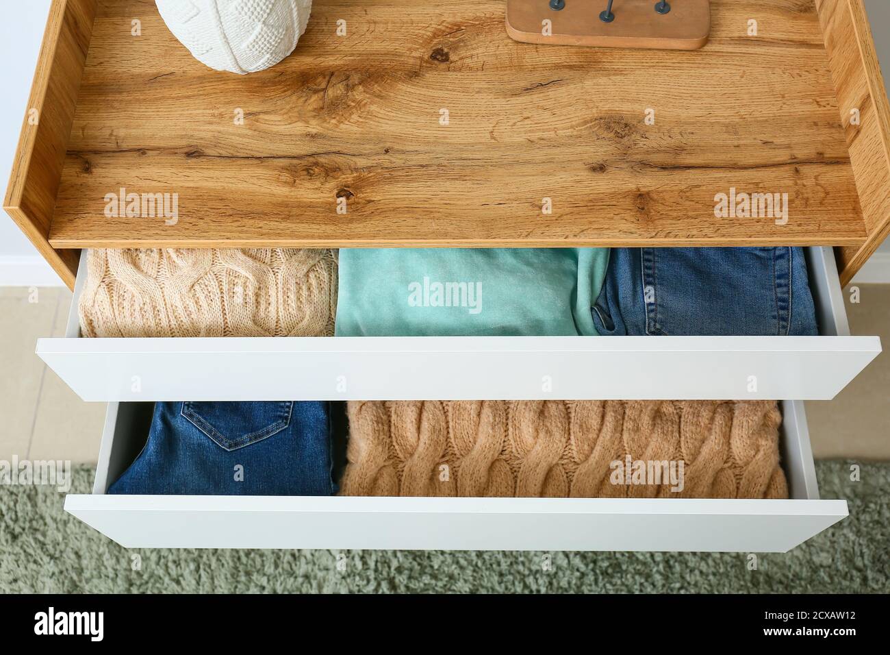 Modern chest of drawers with clothes in room, top view Stock Photo - Alamy