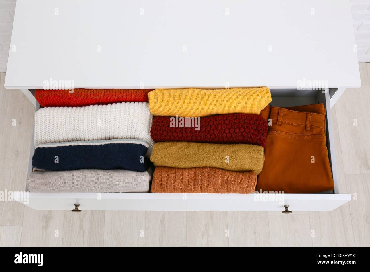 Modern chest of drawers with clothes in room, top view Stock Photo - Alamy