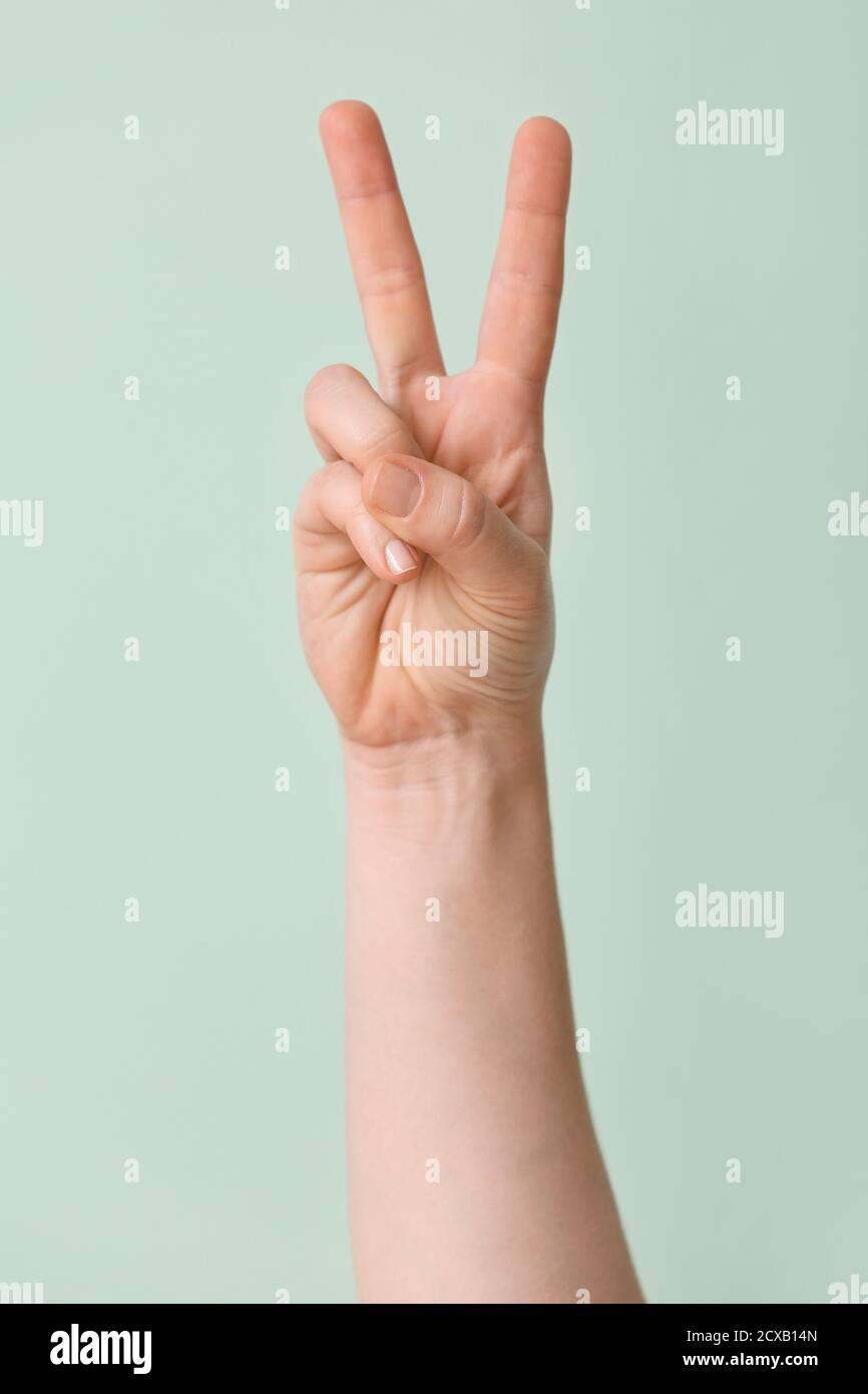 Hand showing letter V on color background. Sign language alphabet Stock ...