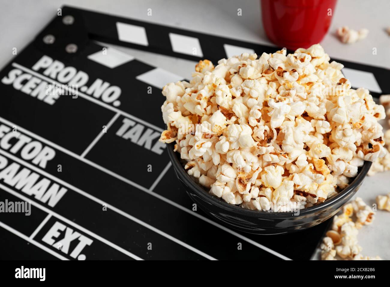 Popcorn and movie clapper on light background Stock Photo - Alamy