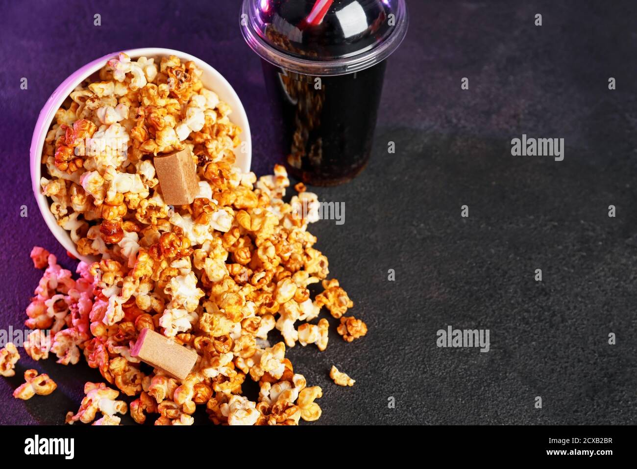 Sweet caramel popcorn with cola on dark background Stock Photo - Alamy