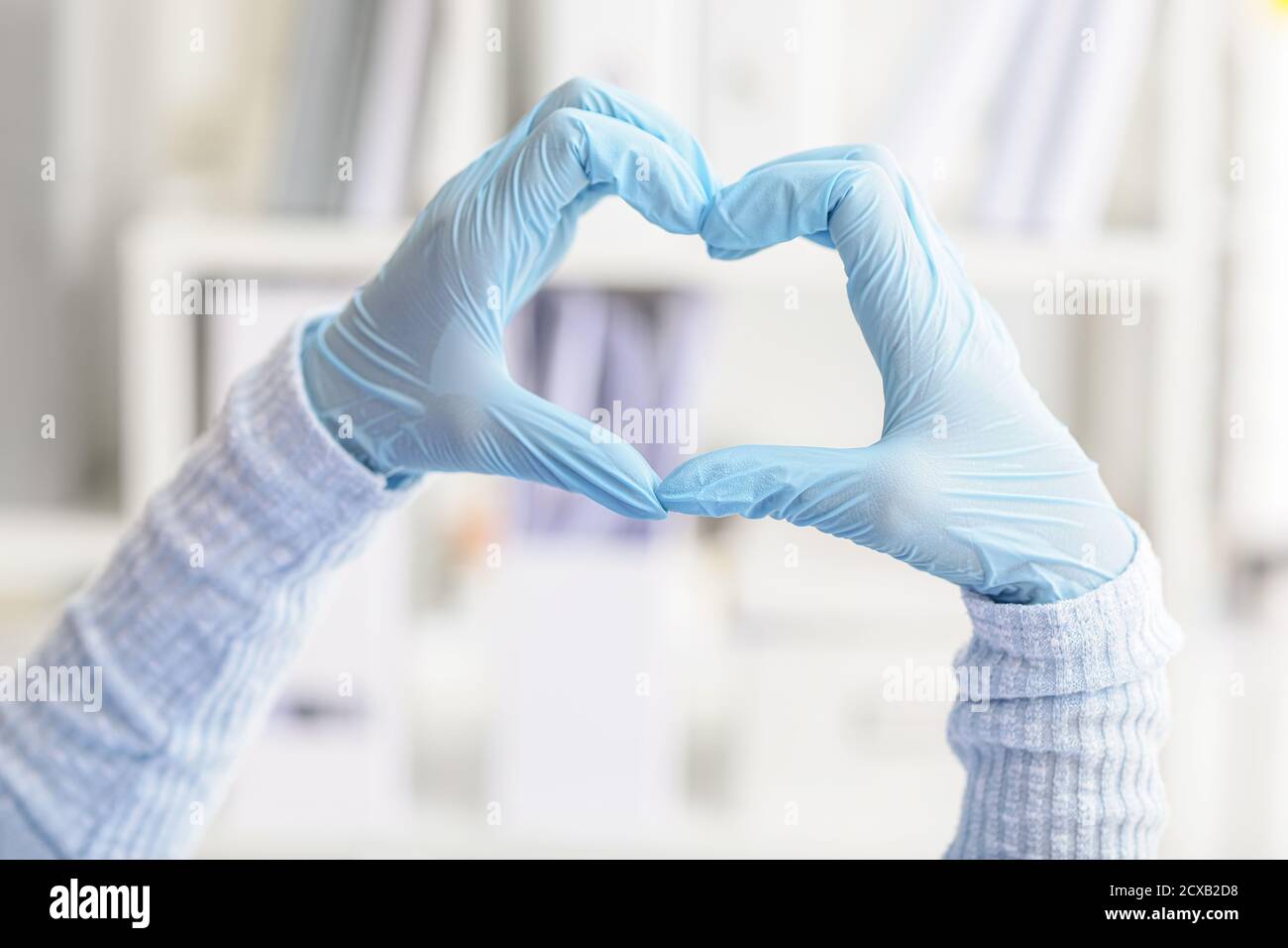 Doctor showing heart shape with hands in clinic Stock Photo - Alamy