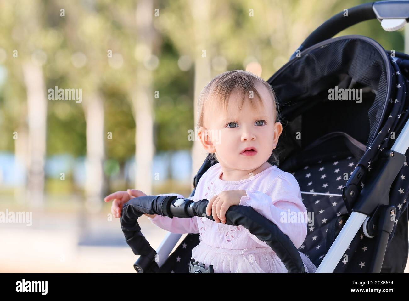 Cute funny baby in stroller outdoors Stock Photo - Alamy
