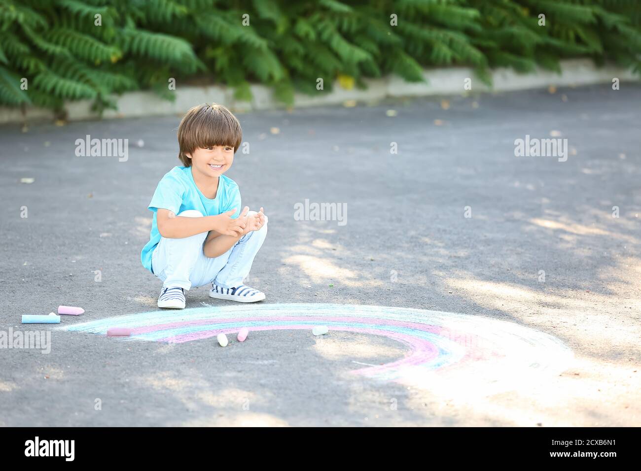 Little boy drawing with chalk on asphalt Stock Photo - Alamy
