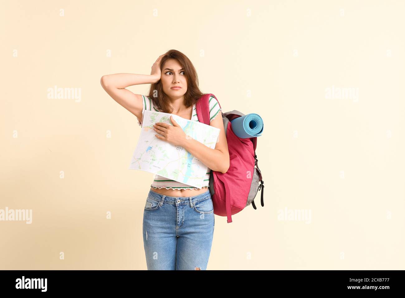 Stressed female tourist with map on color background Stock Photo - Alamy