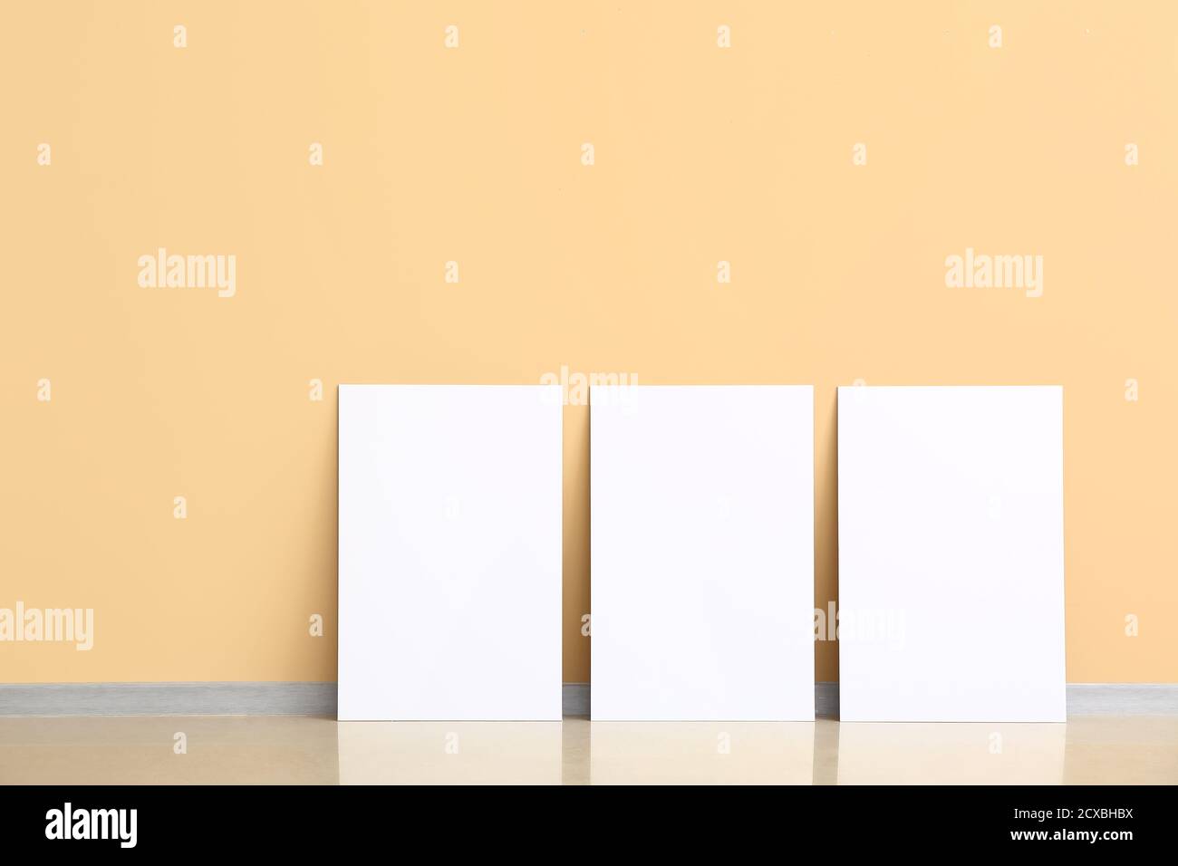 Blank posters near color wall Stock Photo - Alamy