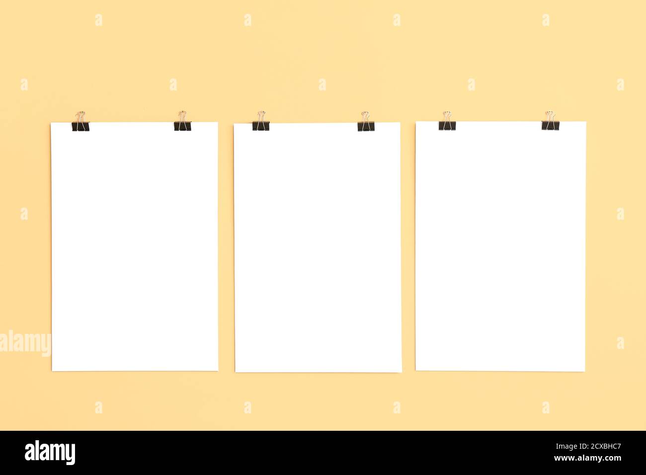 Blank posters hanging on color wall Stock Photo - Alamy