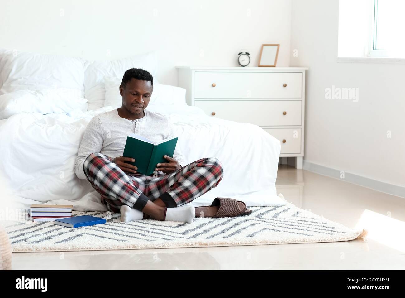 African-American man reading book at home Stock Photo - Alamy