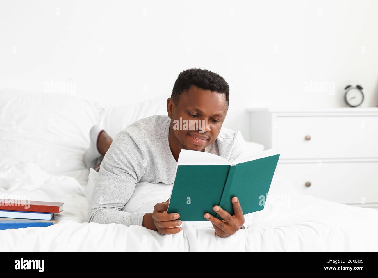 African-American man reading book at home Stock Photo - Alamy