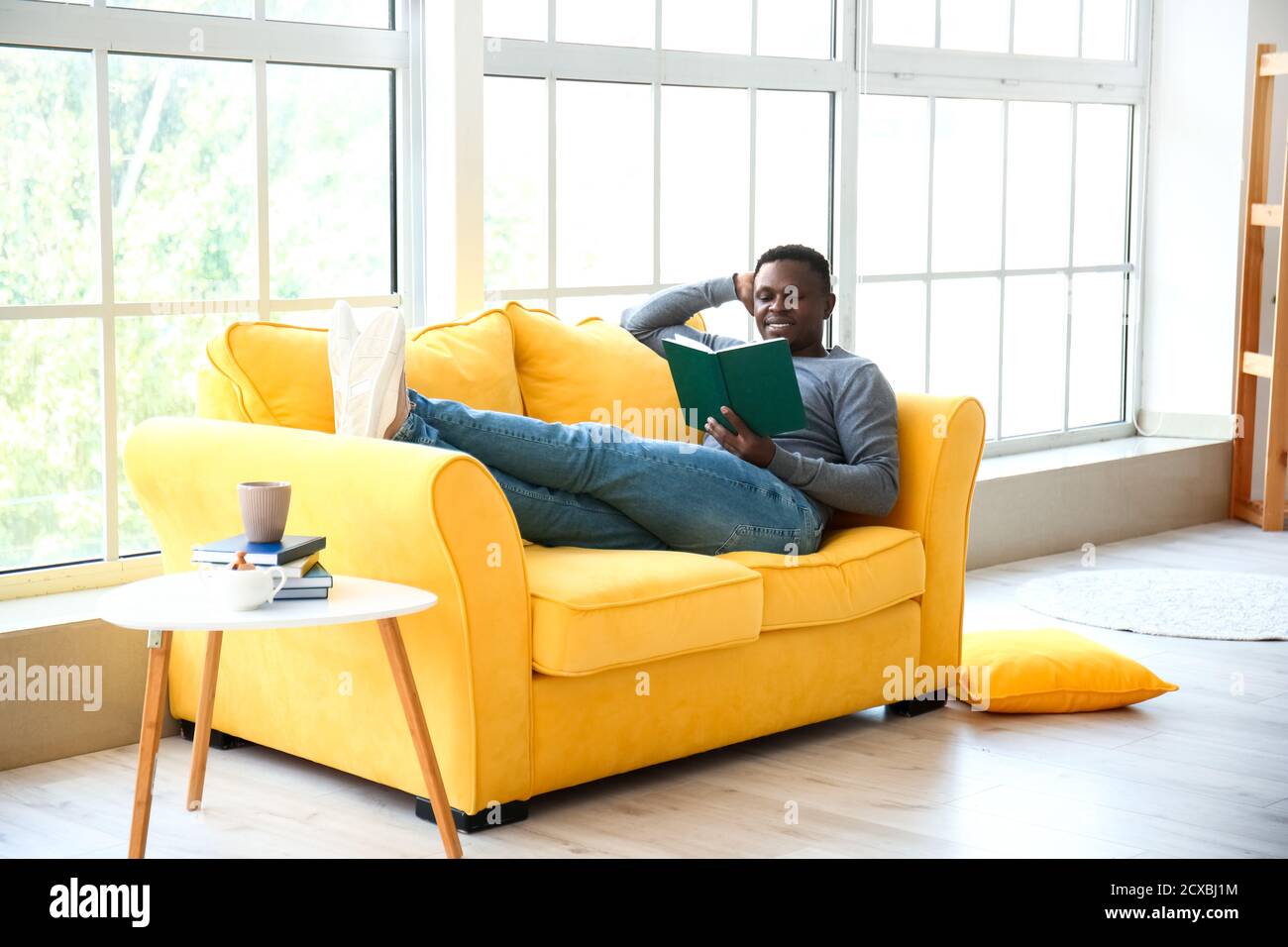 African-American man reading book at home Stock Photo - Alamy