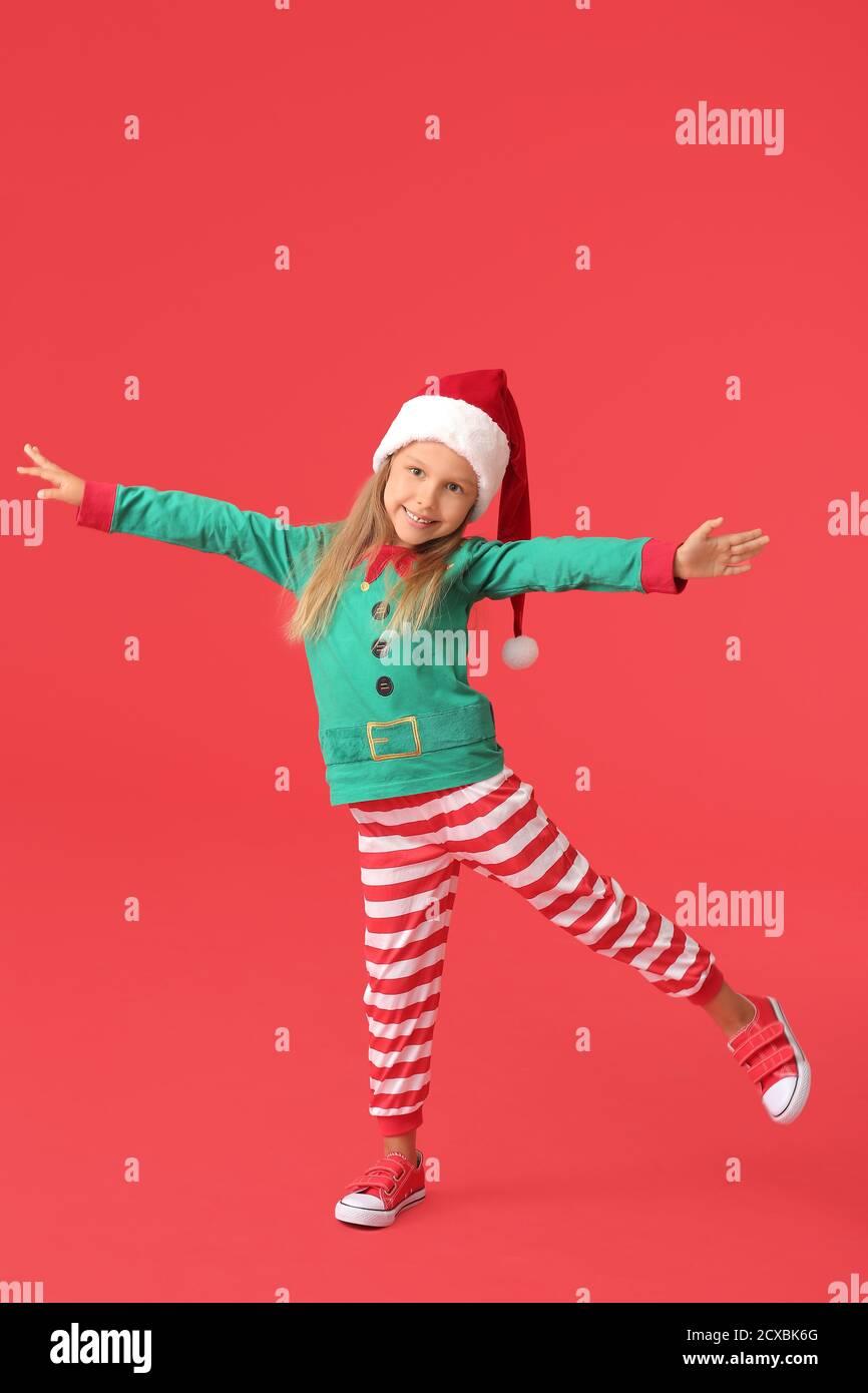 Happy little girl dressed as elf on color background Stock Photo - Alamy