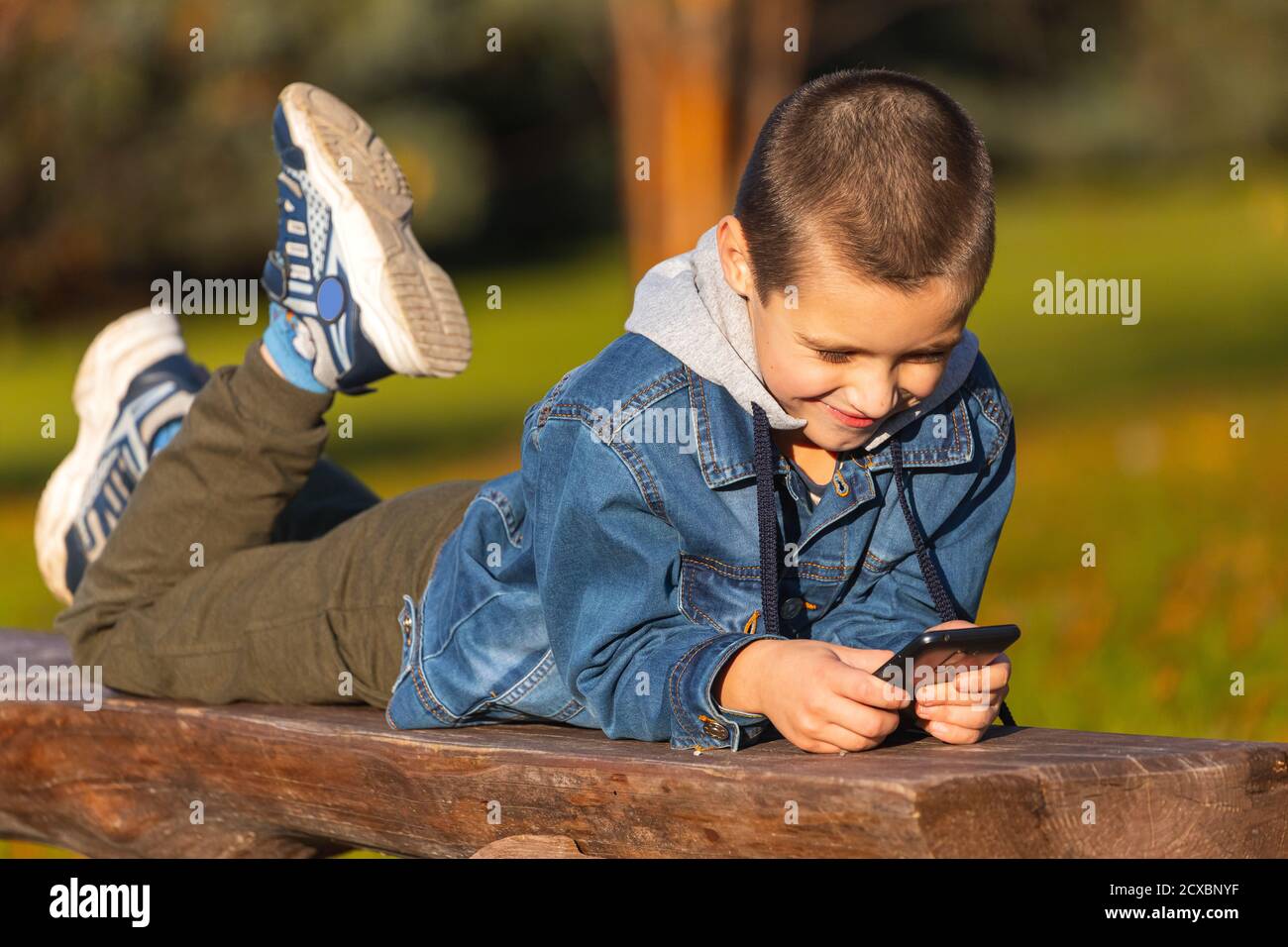 Little boy child playing mobile games on smartphone in the park. Funny ...