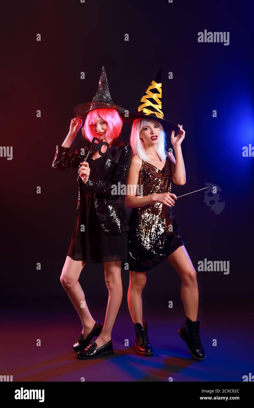 Beautiful young women dressed as witches on dark background. Halloween ...