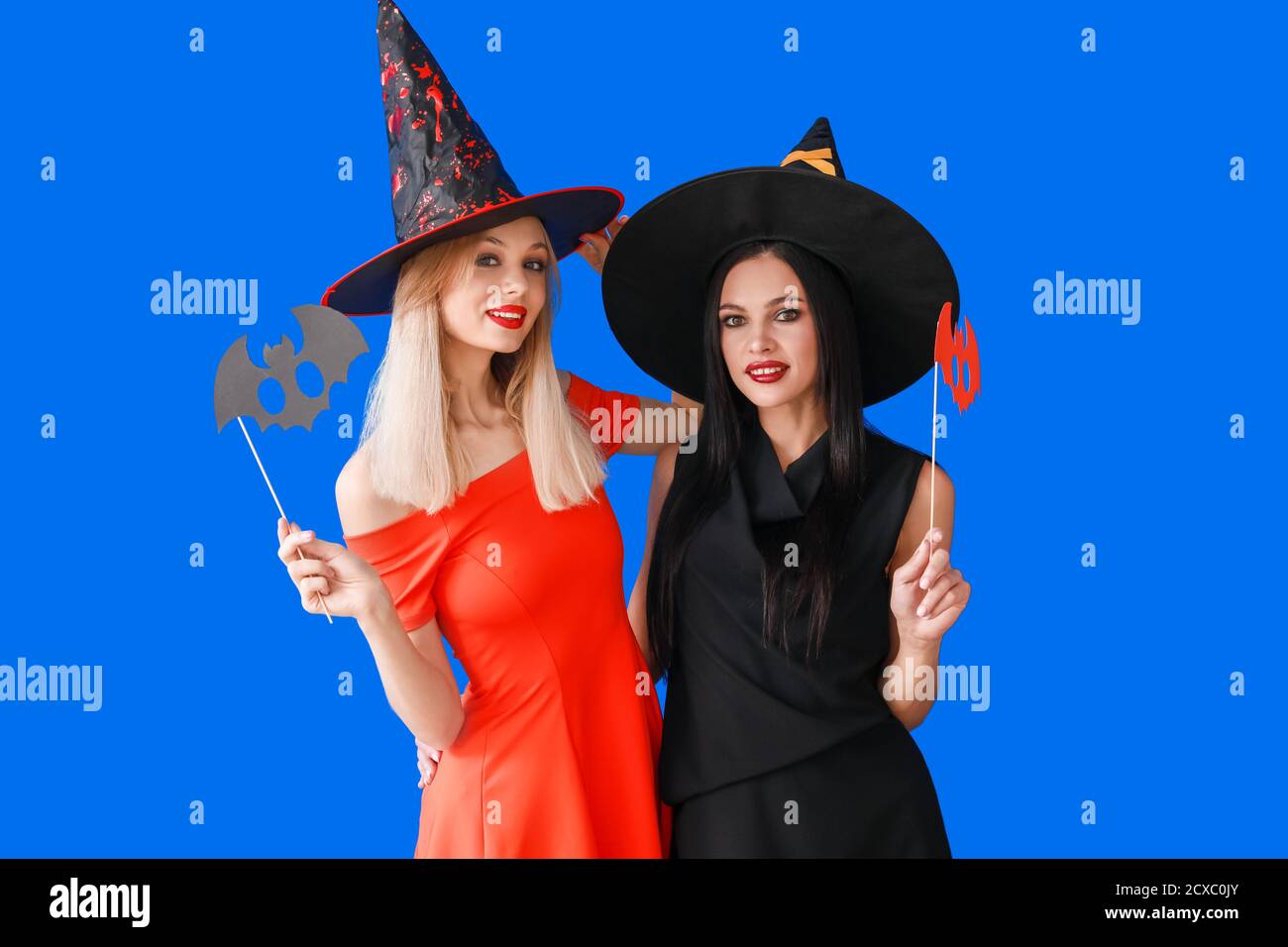 Beautiful young women dressed as witches on color background. Halloween ...