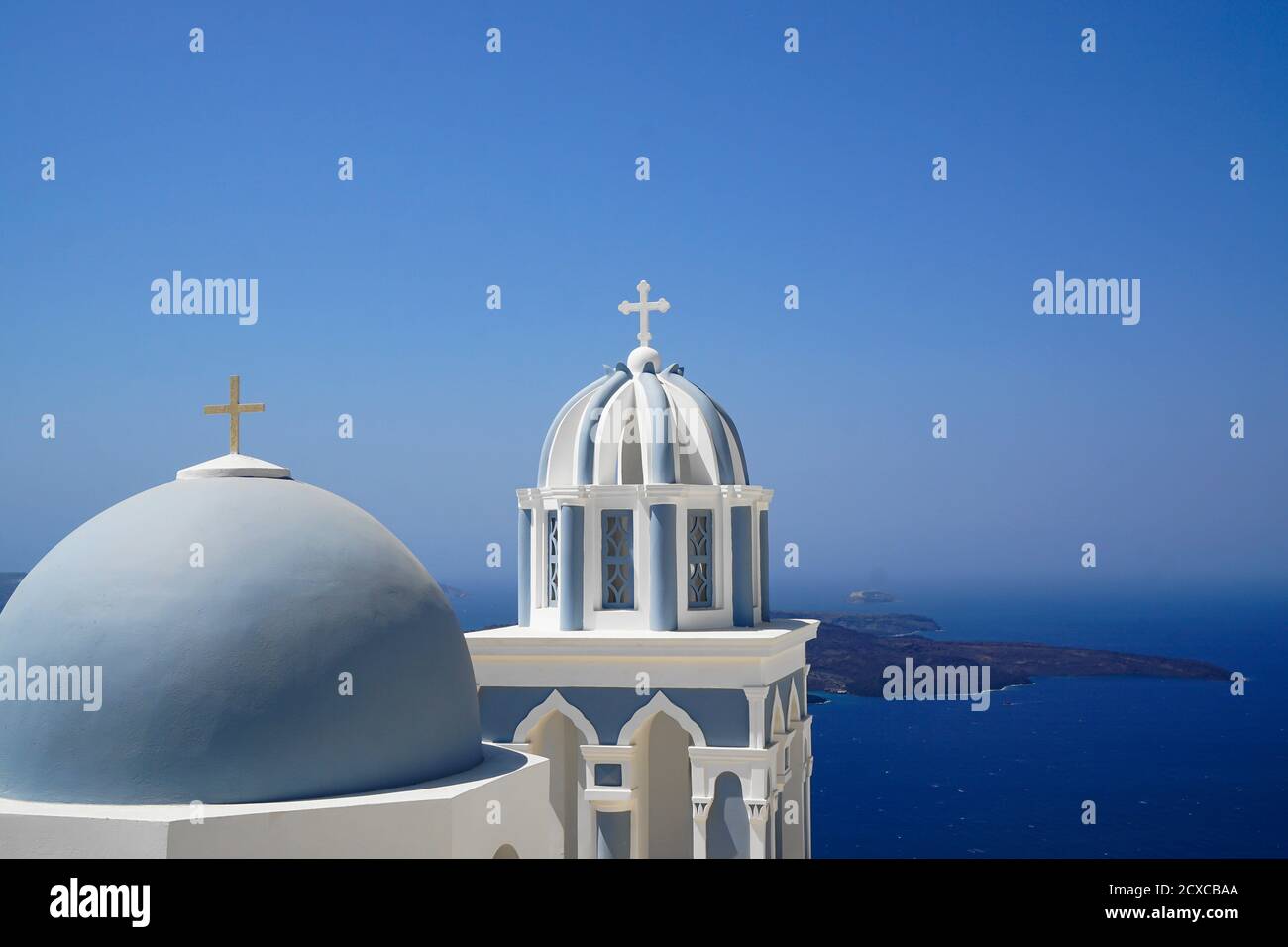 Santorini church towers with crosses and dome against blue water Stock ...