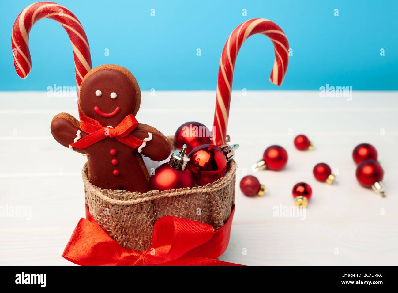 Gingerbread man and candy canes in a basket against blue Stock Photo ...