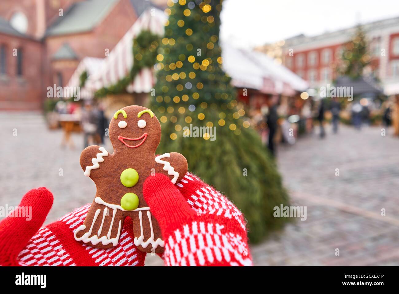 Christmas market in old town European small city. Hand in red mitten ...