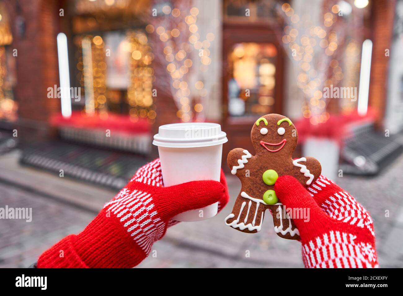Christmas market in old town European small city. Hand in red mitten ...