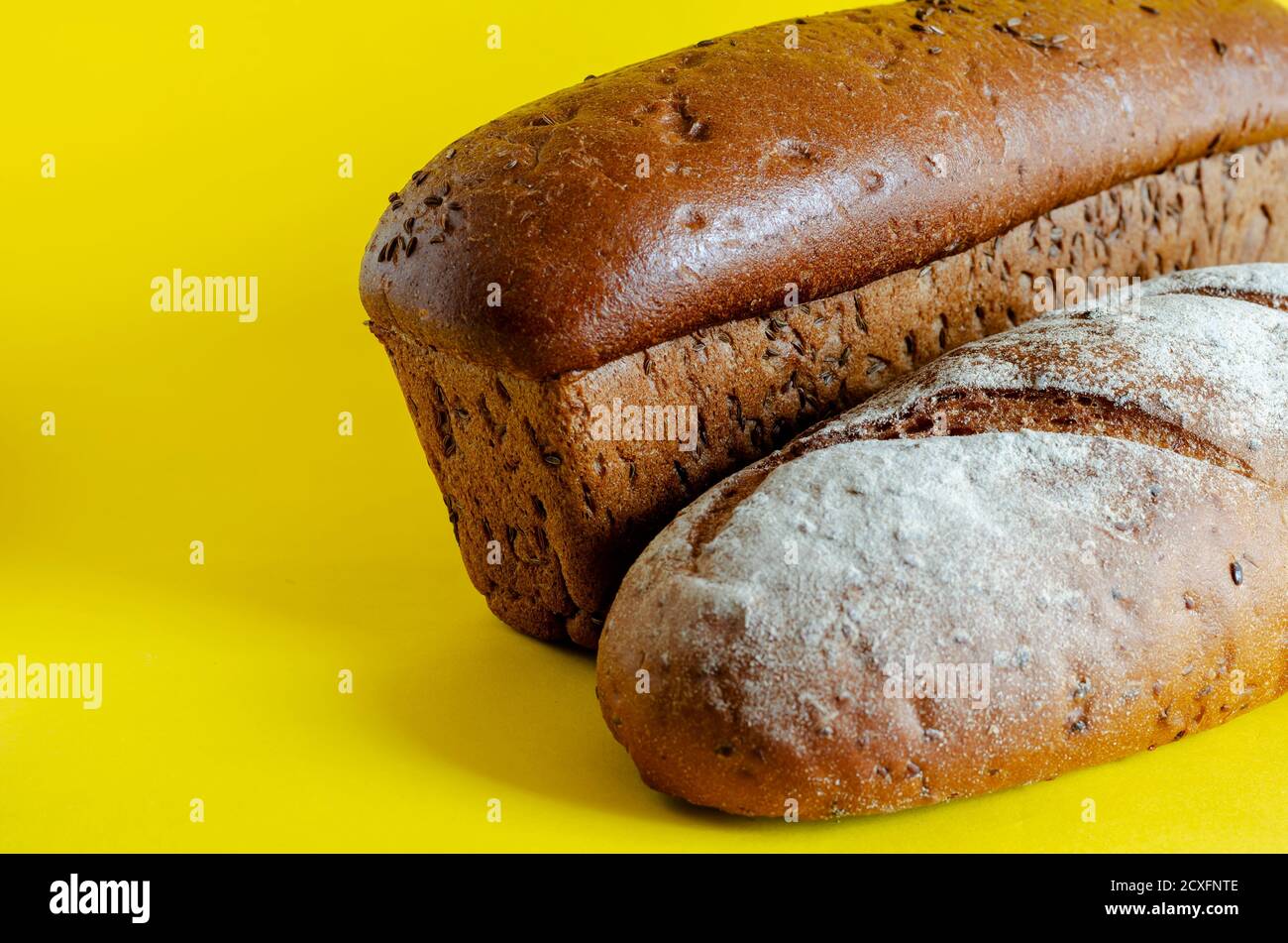 Two random loaves of rye bread on a yellow background. Demonstration of ...