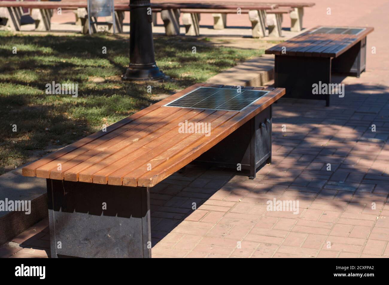 Park bench with solar panel. A row of wooden benches with the ability ...