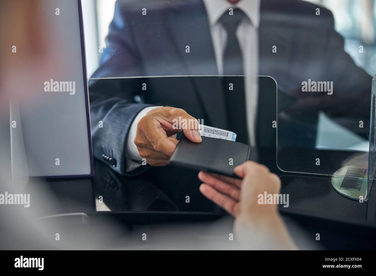 Man giving documents for checking in at airport Stock Photo - Alamy
