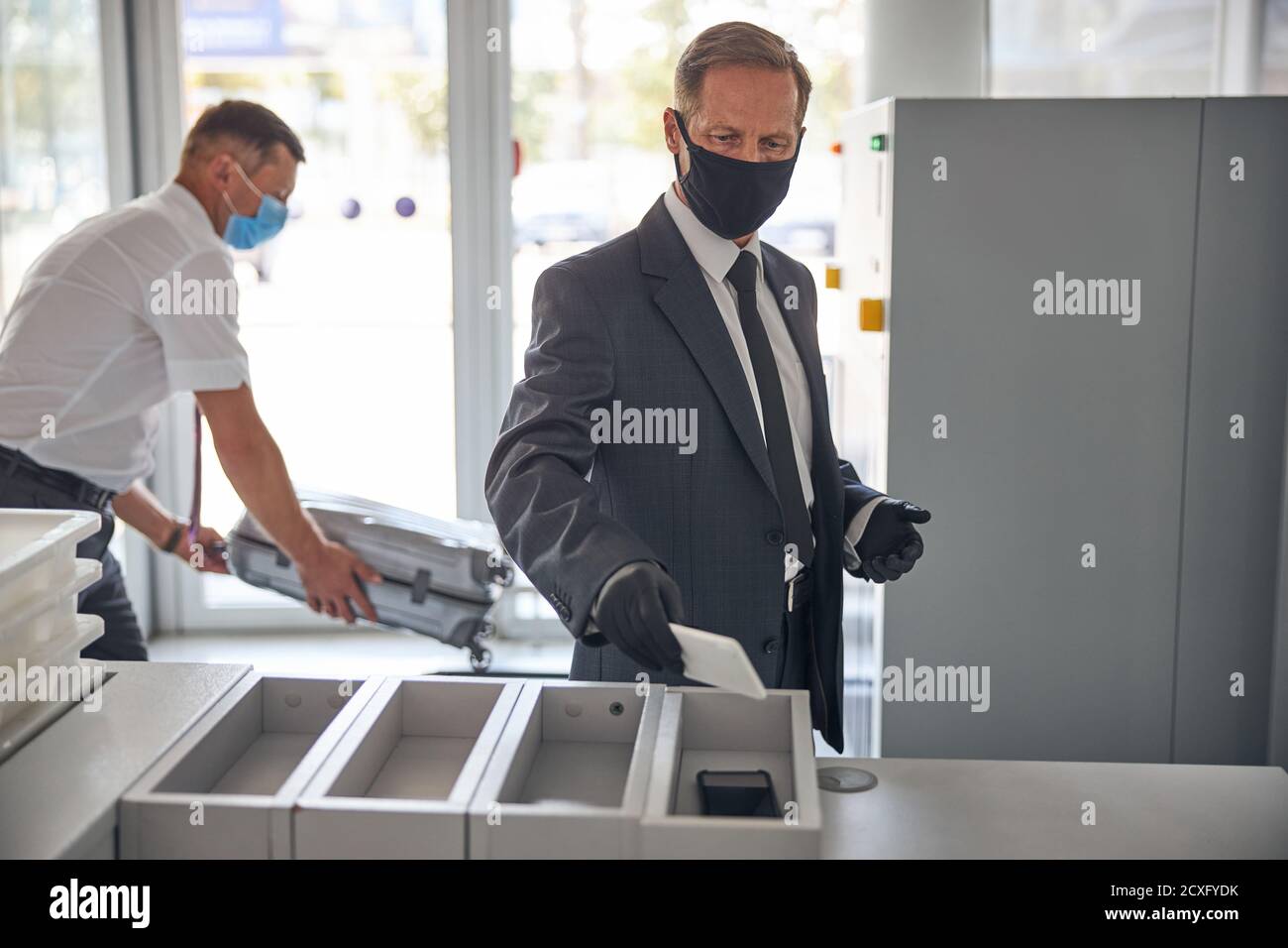 Elegant male walking through customs in airport Stock Photo - Alamy