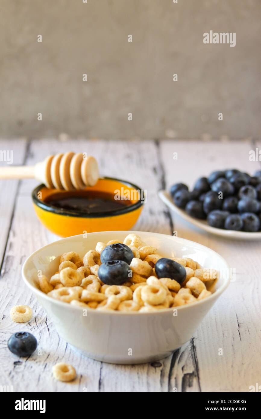 Honey rings with blueberries in a bowl on the table wooden background ...