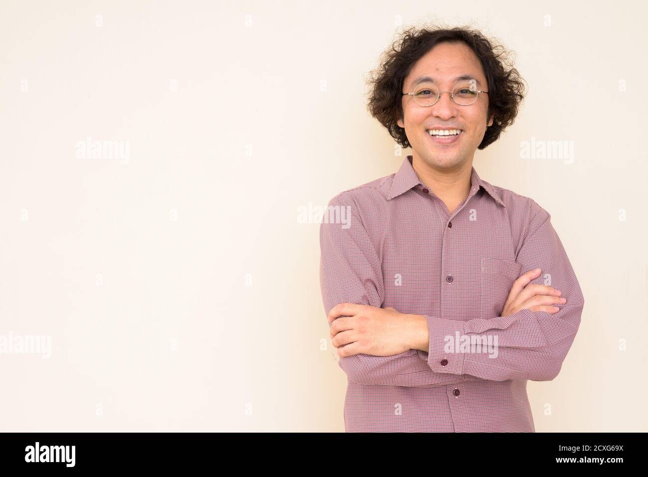 Portrait of happy Japanese businessman smiling with arms crossed Stock ...