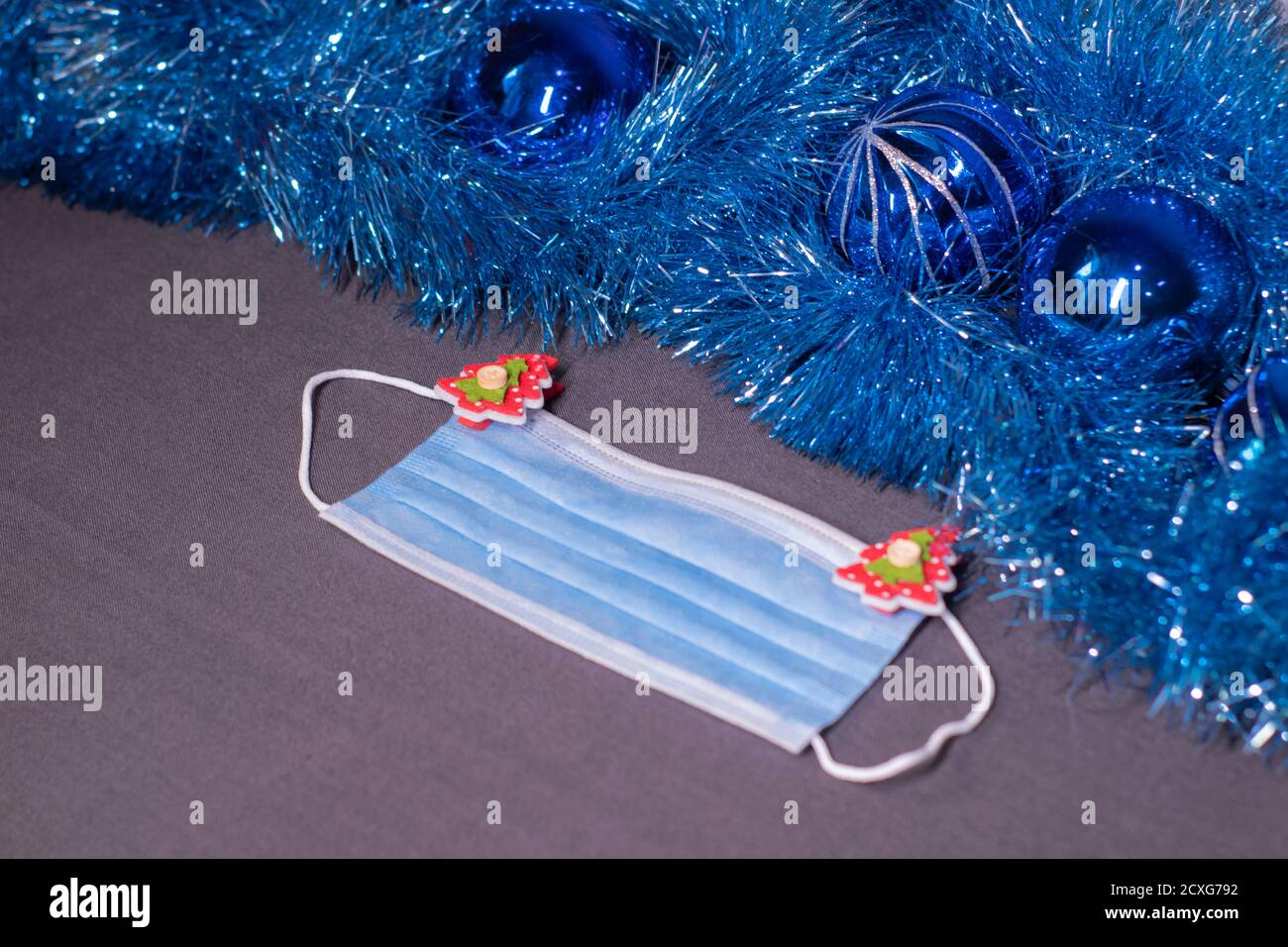 blue medical mask with christmas tree-shaped clothespins. new years ...