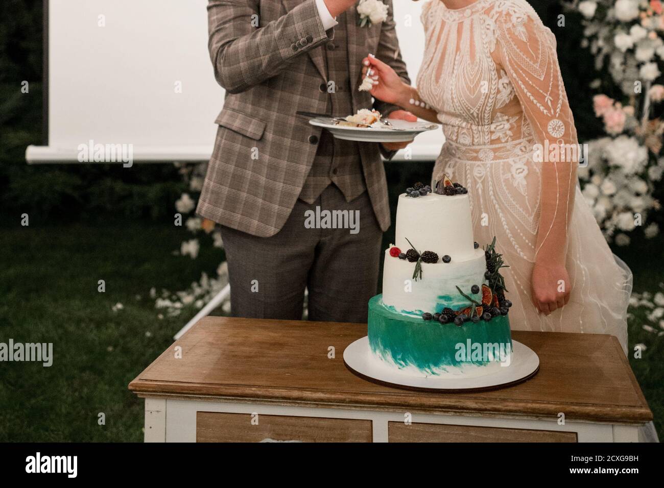 a bride and groom cut the wedding cake Stock Photo - Alamy
