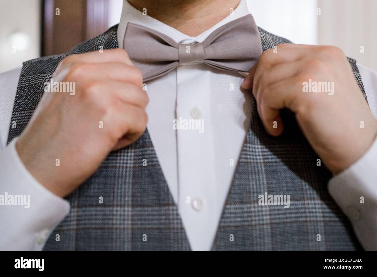 man puts on a bow tie with his hands Stock Photo - Alamy