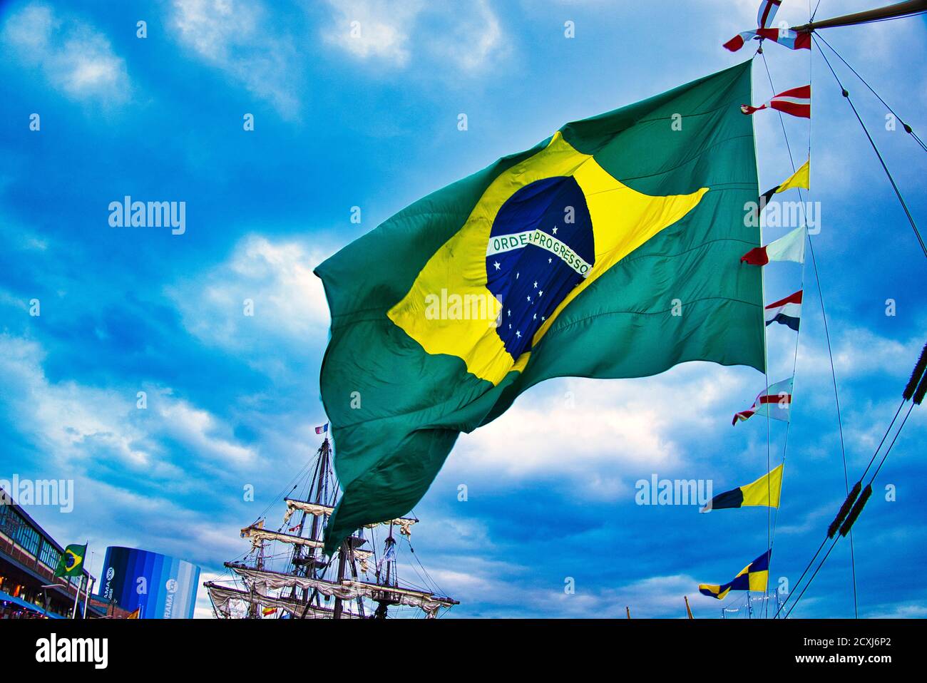 The national flag of Brazil flutters in the wind in cloudy sky, with ...